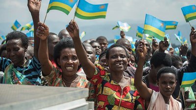 Rwandan's waving the flag of Rwanda.