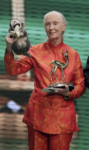 Her standing with her award and monkey stuffed animal