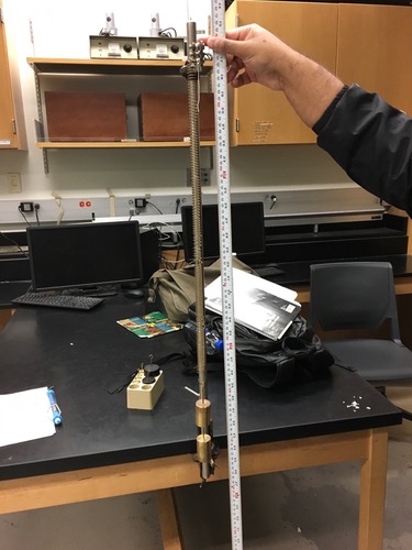 Figure 1:Rod clamped to table, holding mounted spring and 400g weight.