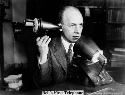 Graham Bell, the inventor of the telephone, using his invention