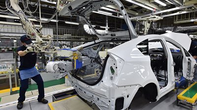 "An employee loads a main battery of the hybrid system on an assembly ...