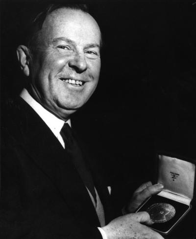 Lester B. Pearson holding the Nobel Peace Prize in his hands