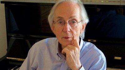 Howard Becker sentado apoiando a mão no rosto.