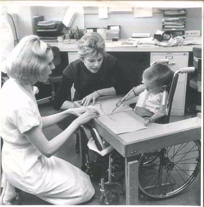 A child learning how to use his prosthetic arm with the help of an ...