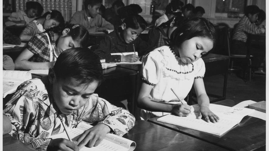 This is a photo of Native American children working on their schoolwork.
