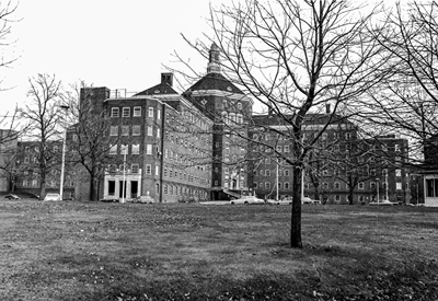[Image description: A school campus with bare trees in front lawn.] The ...