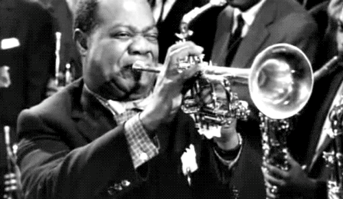 Louis Armstrong playing music with his band at a concert